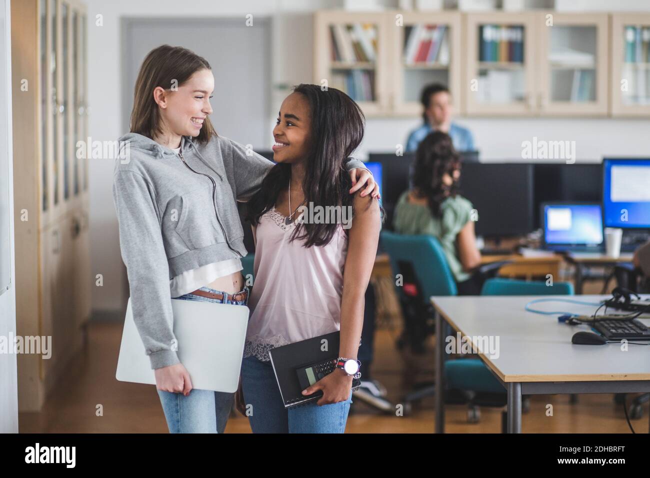 Smiling female students standing in computer lab at high school Stock ...