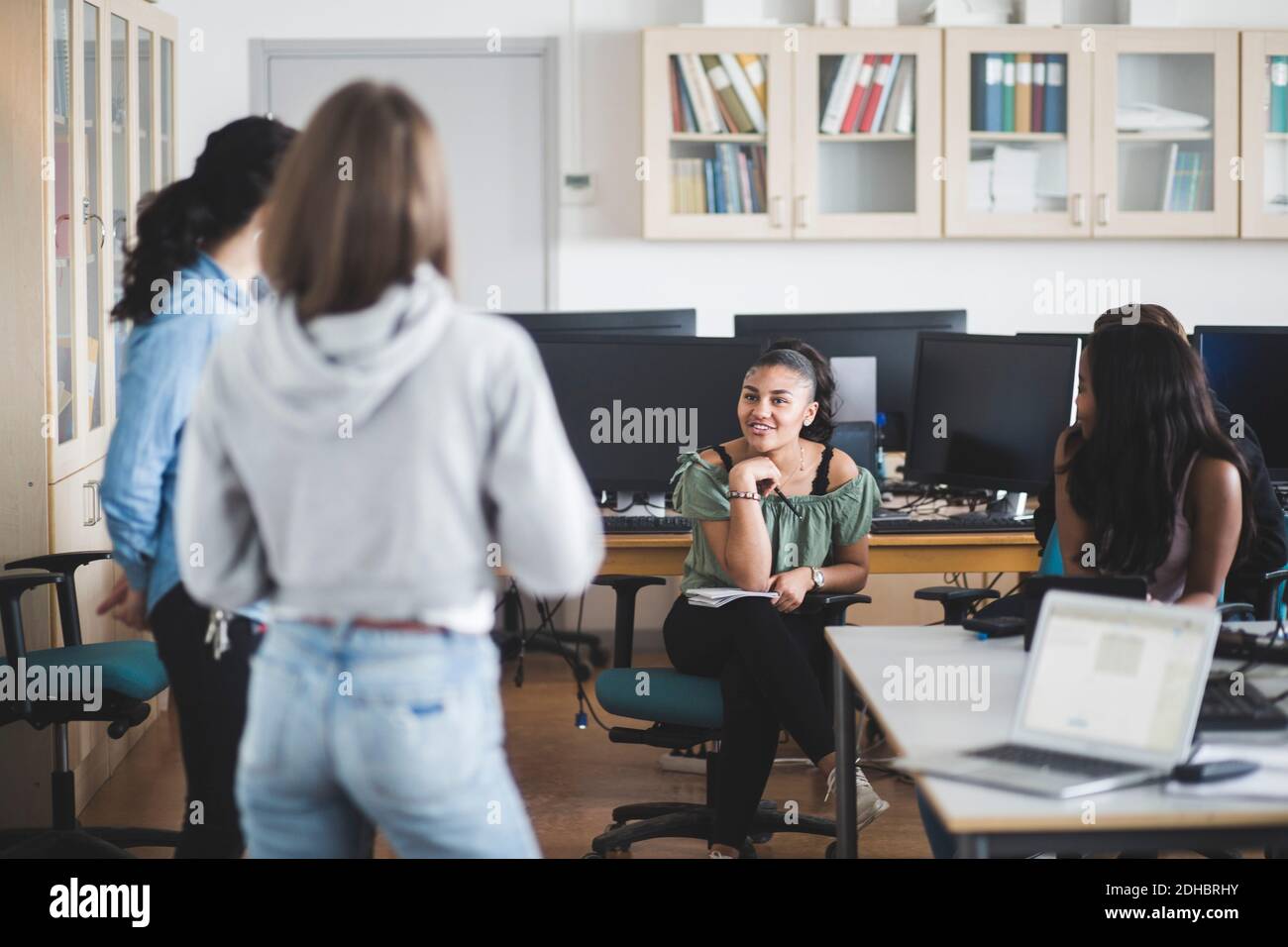Smiling female high school students with teacher in computer lab Stock ...