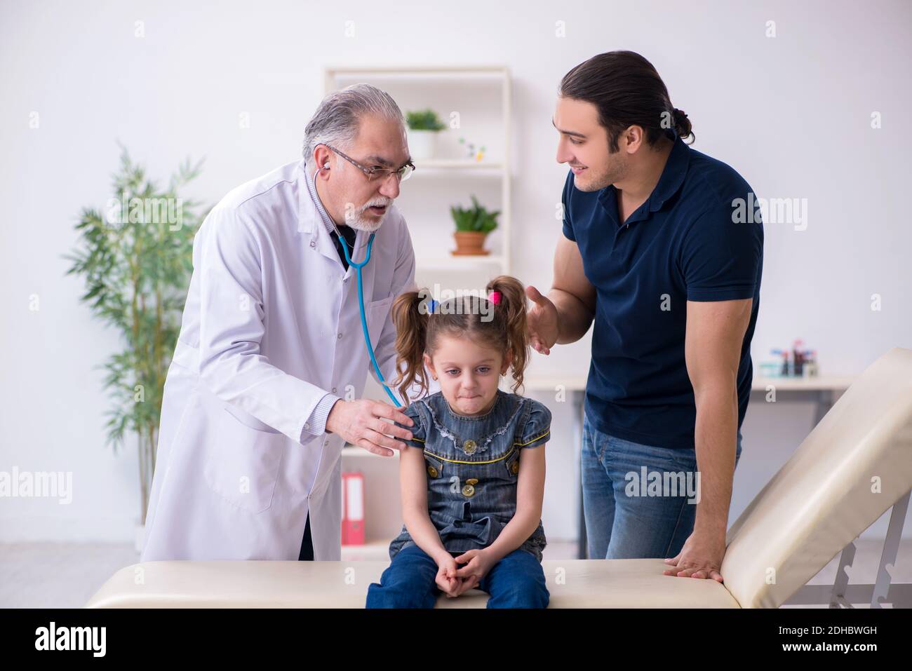 Young father and his daughter visiting old male doctor Stock Photo - Alamy