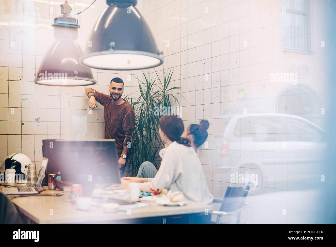 Male hacker explaining strategy to female colleagues at small office ...