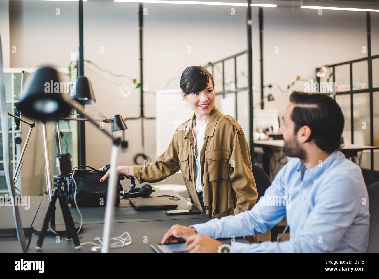 Creative business people talking while working at desk in office Stock ...