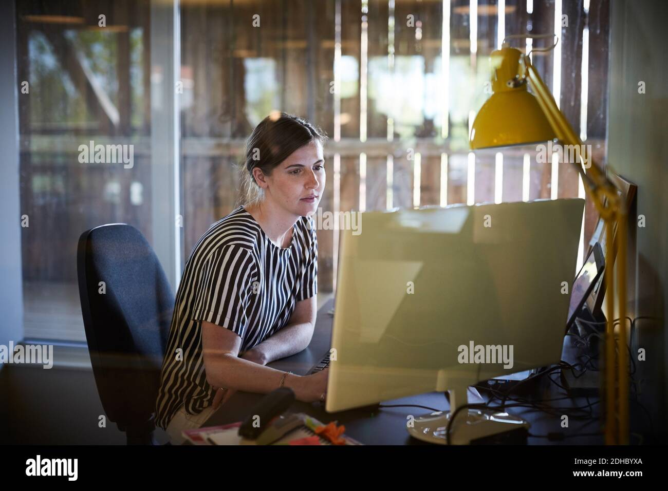 Creative businesswoman using computer at desk in office Stock Photo - Alamy