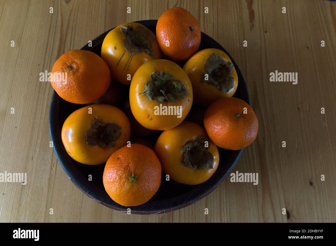 Kakis and tangerines in a bowl Stock Photo - Alamy