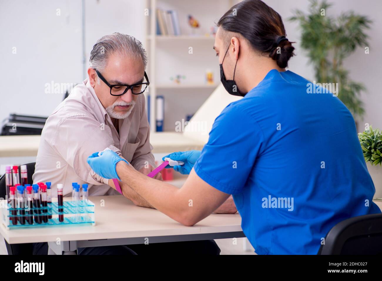 Old patient visiting young male doctor in blood transfusion conc Stock ...