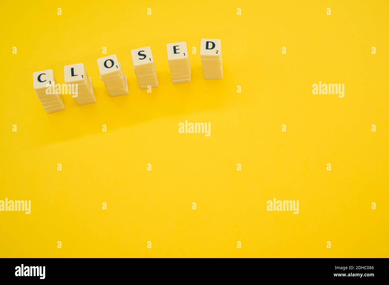 The six white letter block stacks forming the word CLOSED on yellow ...