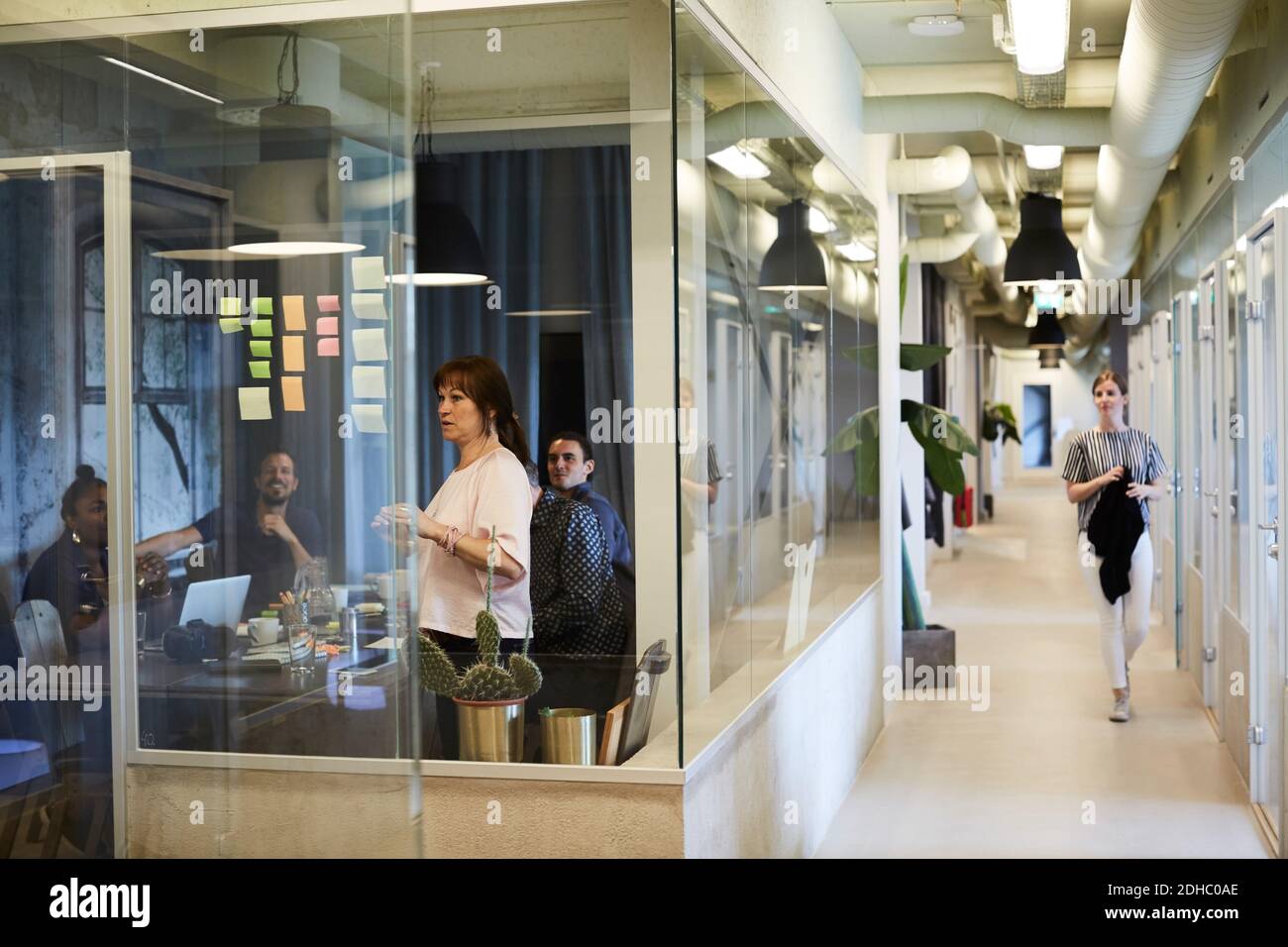 Business people brainstorming ideas in board room while female ...
