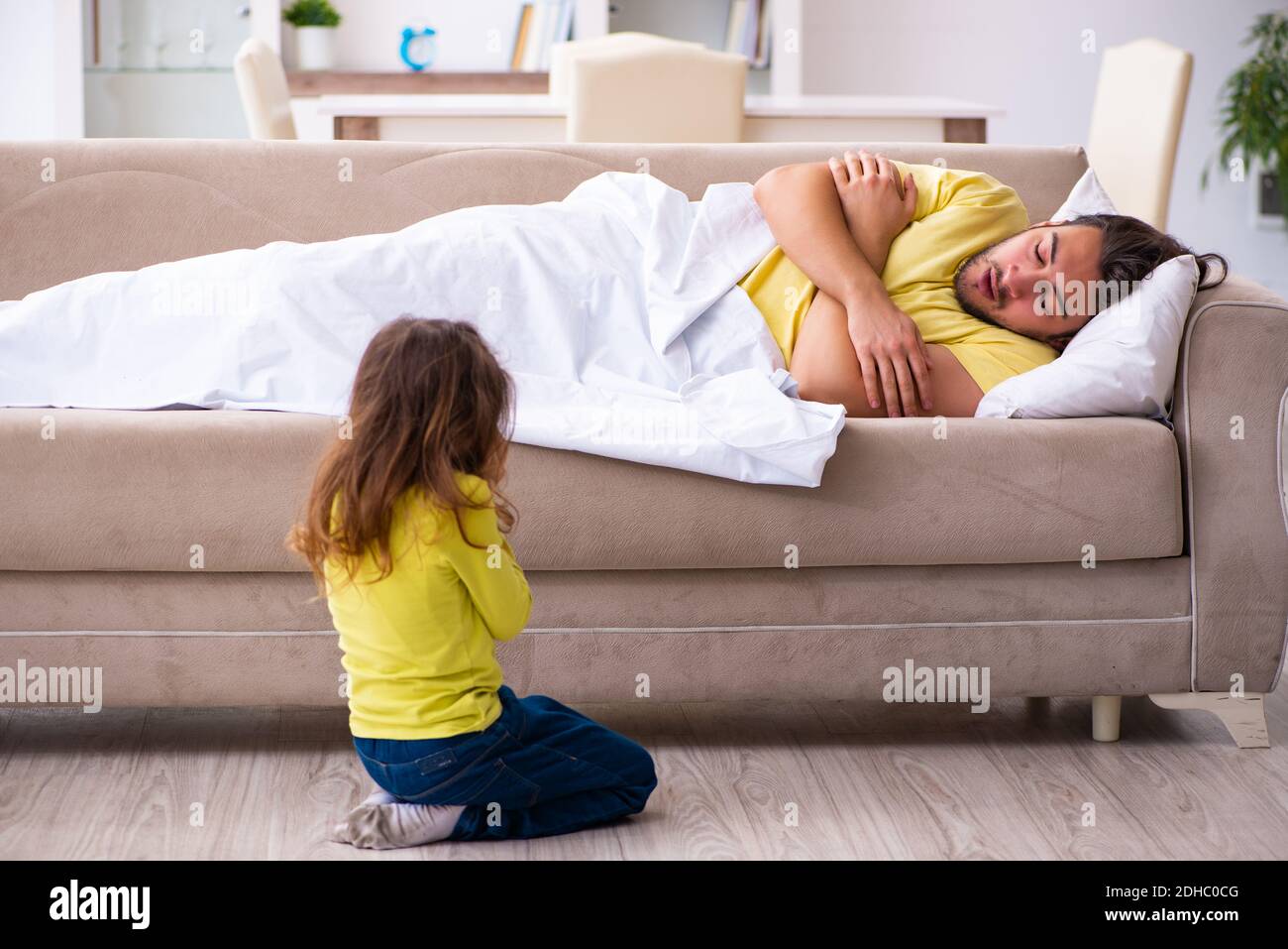 Small girl looking after her sick father Stock Photo - Alamy