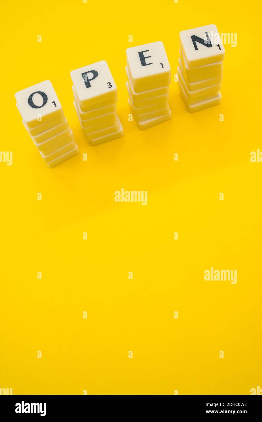 The four white letter block stacks forming the word OPEN on a yellow ...