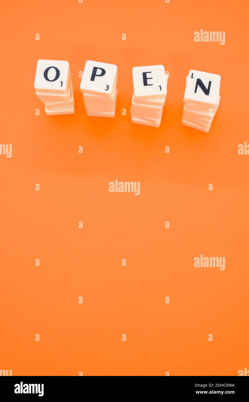 The four white letter block stacks forming the word OPEN on an orange ...