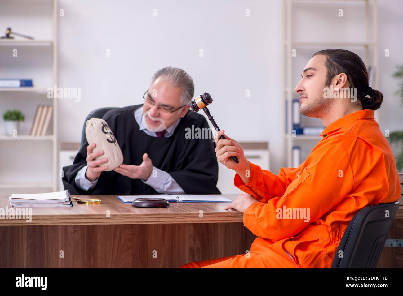 Old male judge meeting with young captive in courthouse Stock Photo - Alamy