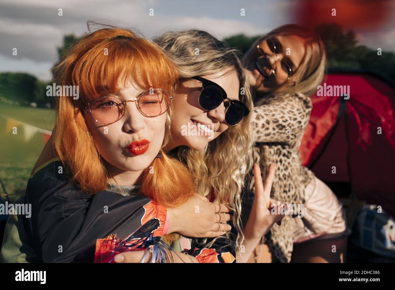 Smiling friends gesturing while enjoying in party at music festival ...