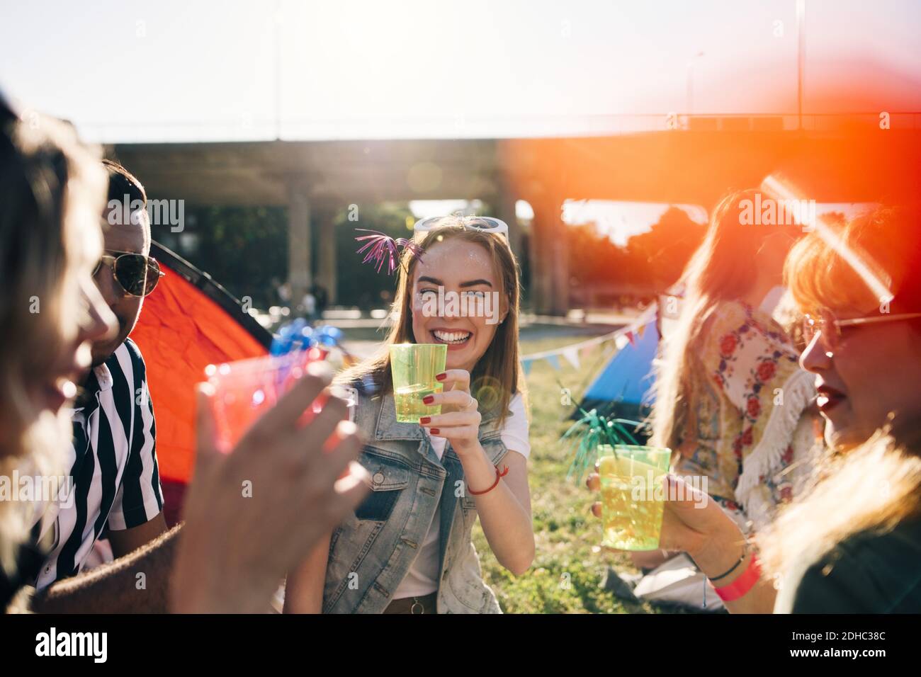 Smiling friends enjoying drinks in music concert during summer Stock ...