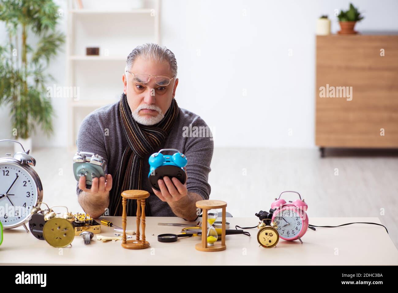 Old male watchmaker working in the workshop Stock Photo - Alamy