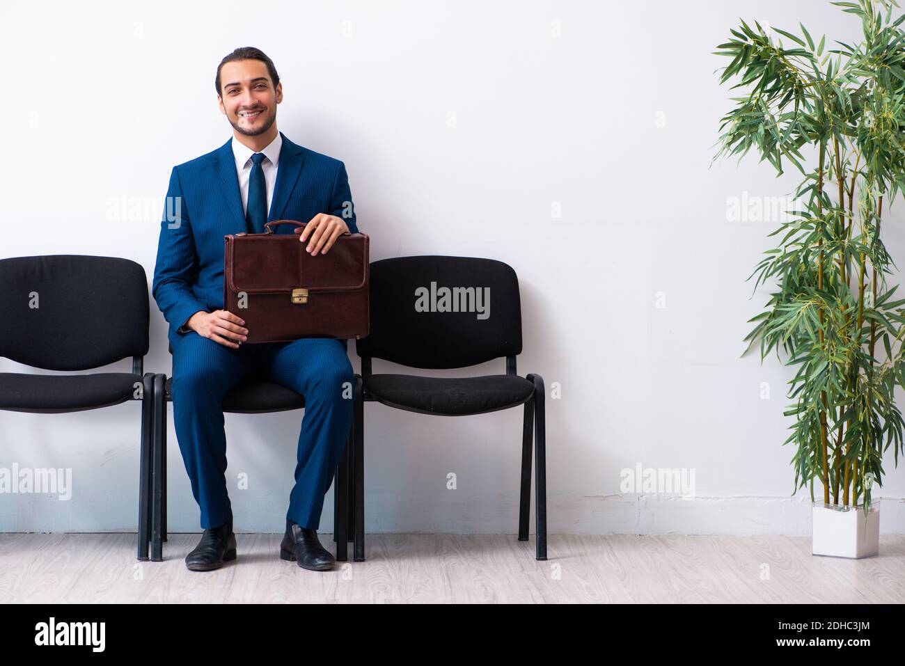 Young businessman waiting for an interview at hall Stock Photo - Alamy