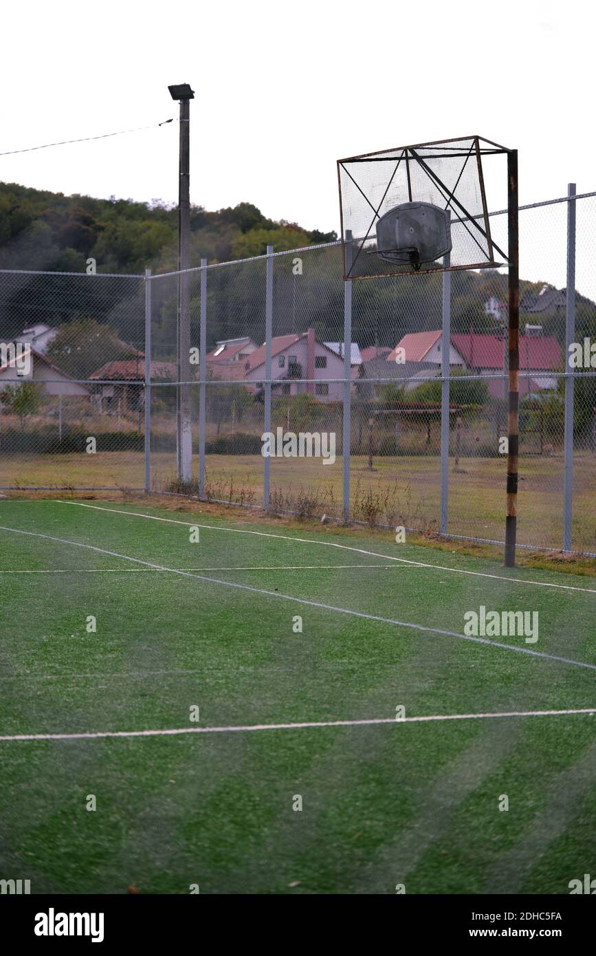A small football pitch surrounded by fences in a school playground area ...