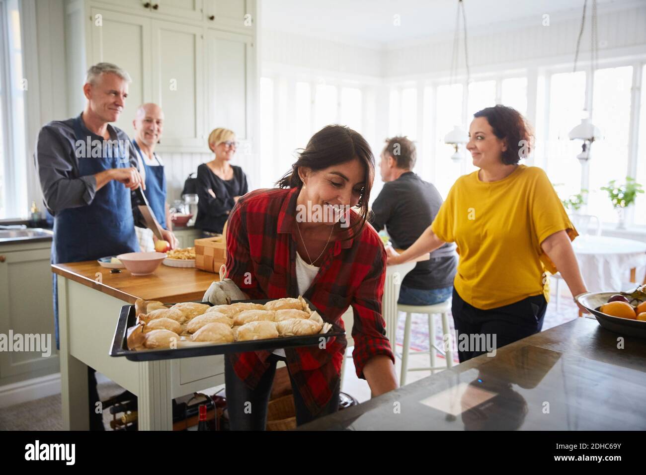 Happy friends preparing food together in kitchen at home Stock Photo ...