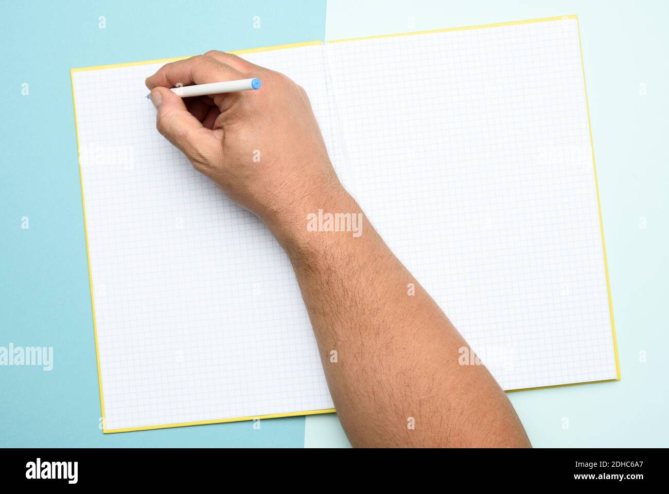 Male hand holding open notepad with empty white sheets Stock Photo - Alamy