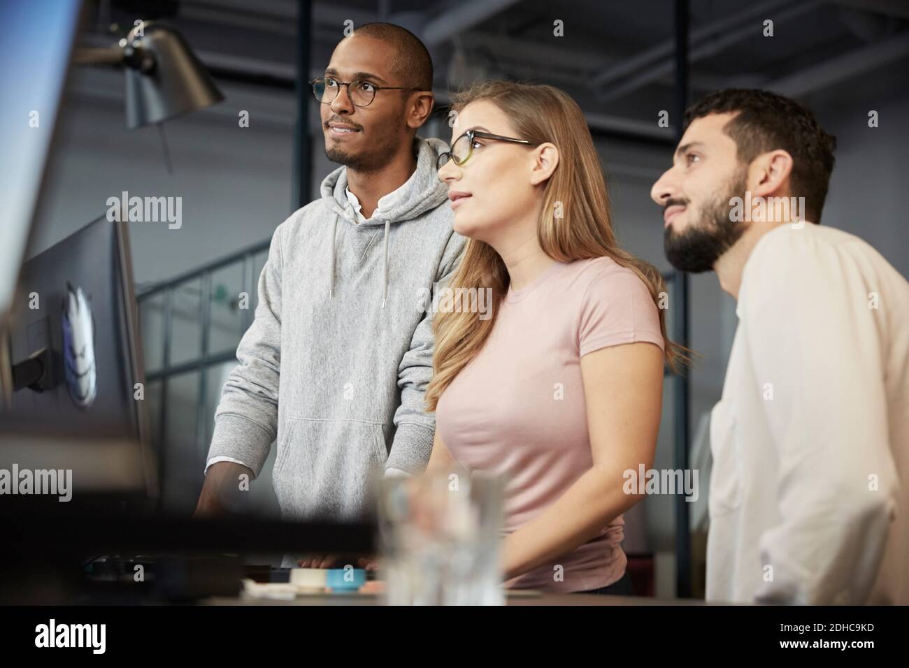 Creative business people watching presentation at desk in office Stock ...