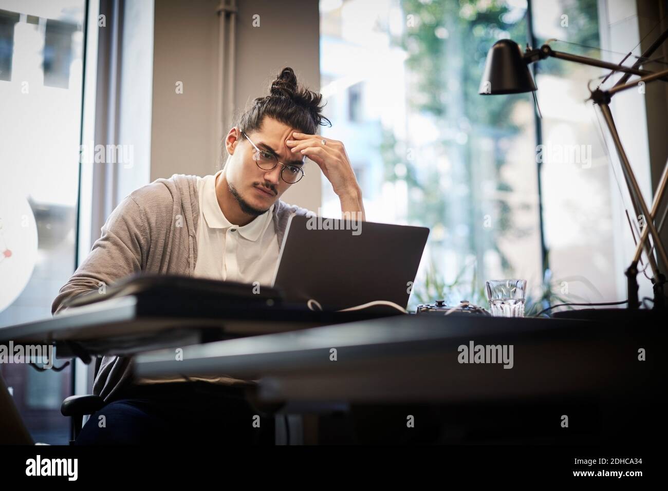 Tensed young businessman using laptop hi-res stock photography and ...