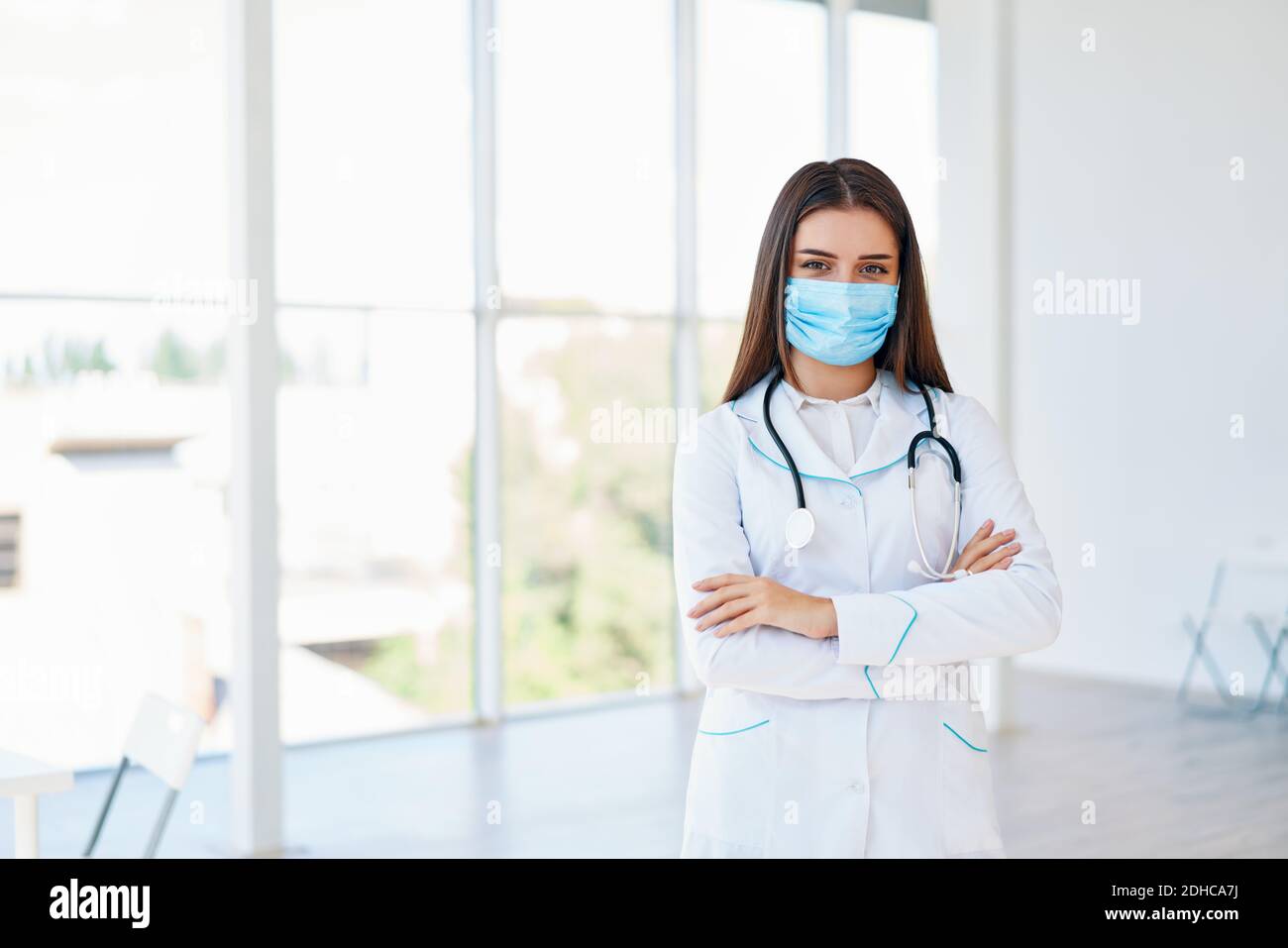 Female doctor wearing medical mask with arms crossed in hospital ...