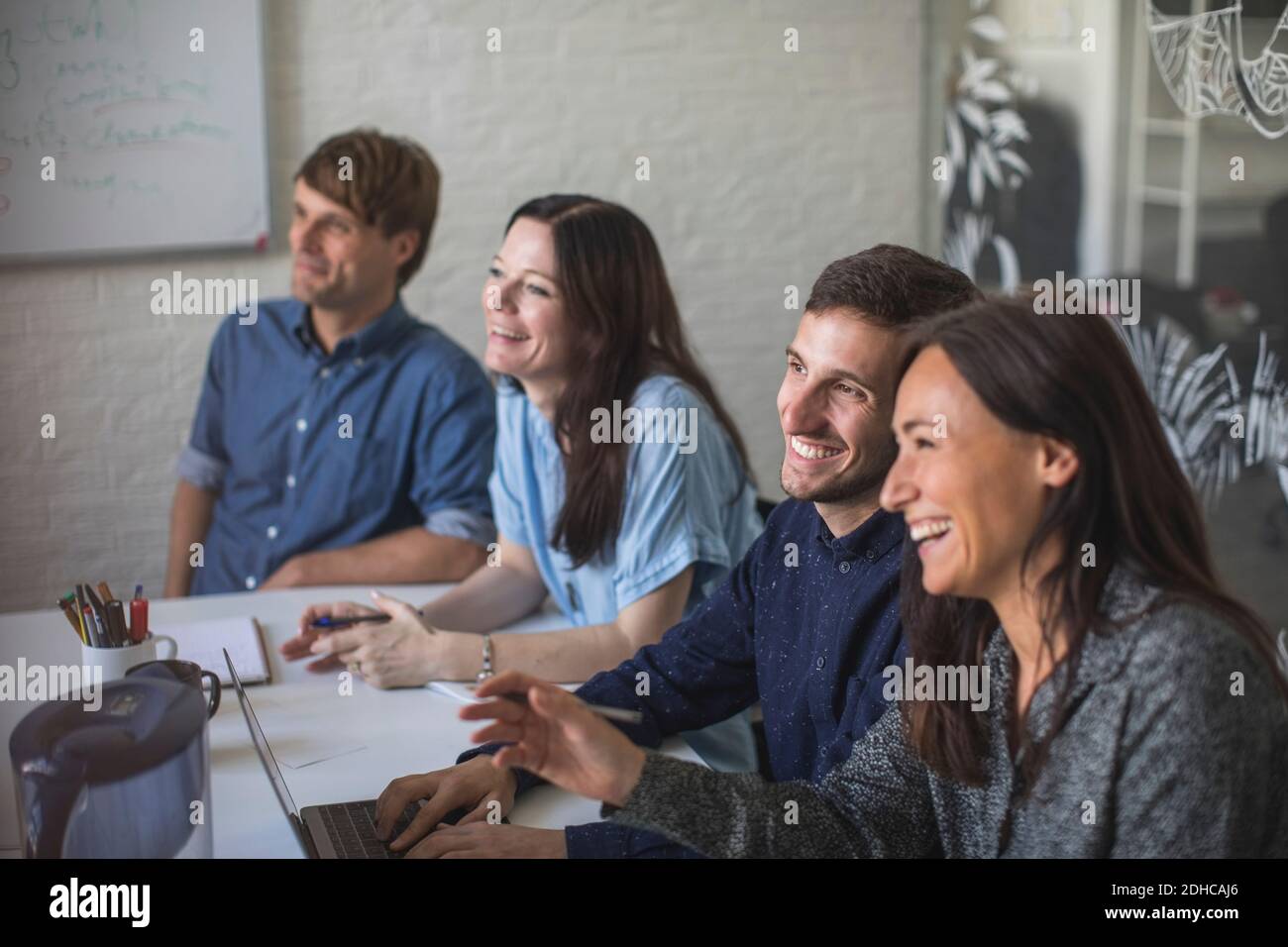 Creative business professionals smiling while sitting at conference ...