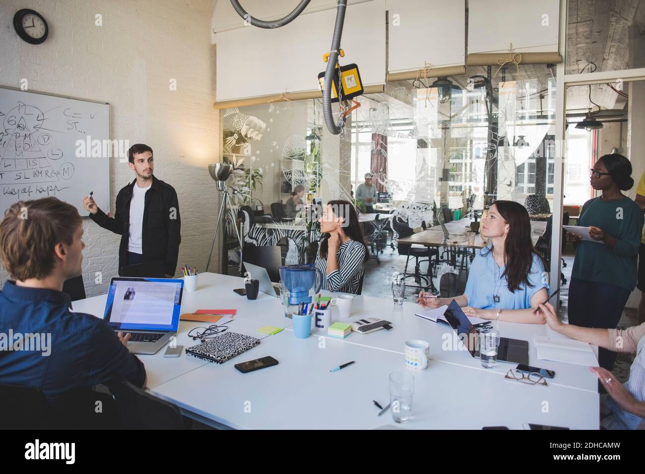 Creative businessman brainstorming colleagues during meeting in board ...