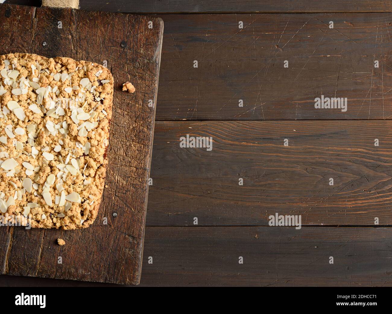 Baked rectangular crumble cake with fruit filling on wooden board, gray ...