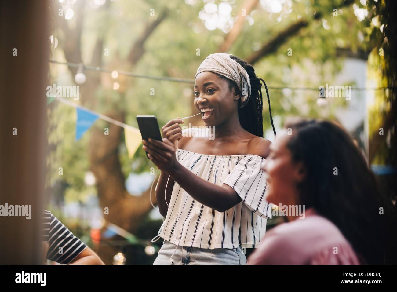 Cheerful young woman video conferencing through mobile phone while ...