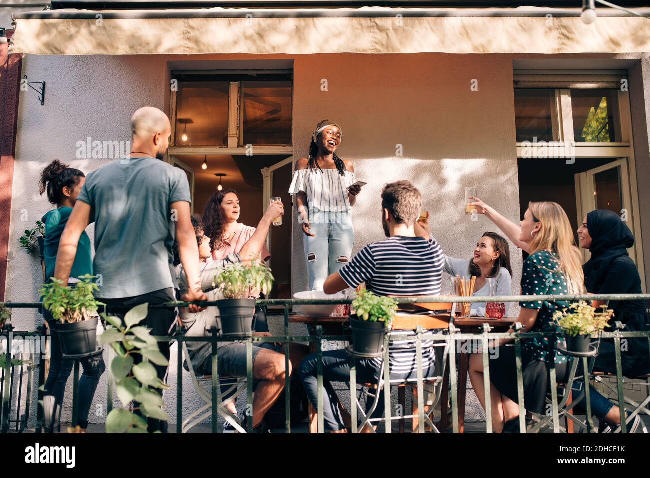 Multi-ethnic friends enjoying at balcony during party Stock Photo - Alamy
