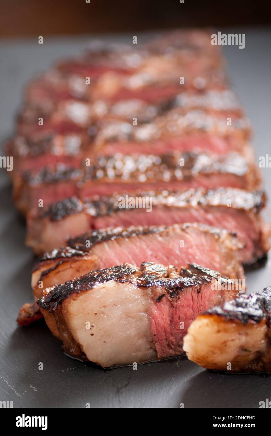 thick ribeye steak seared rare on a cast iron grill Stock Photo - Alamy
