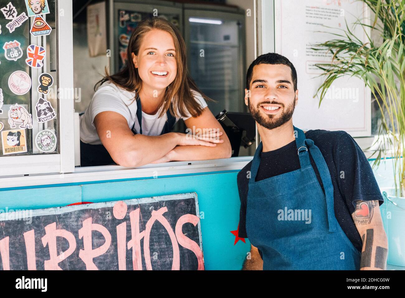 Portrait of smiling young male and female salesman at concession stand ...
