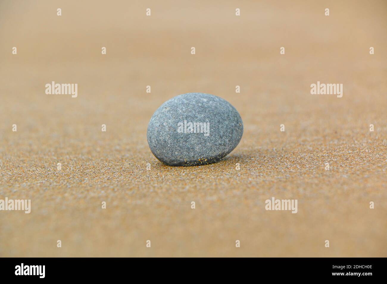 Single round stone on the beach Stock Photo - Alamy