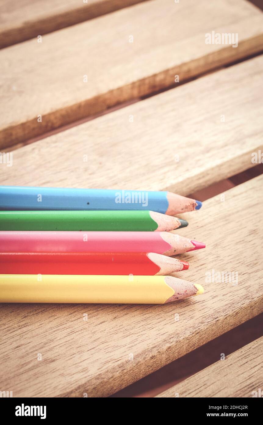 A vertical shot of some colored pencils on a wooden surface Stock Photo ...