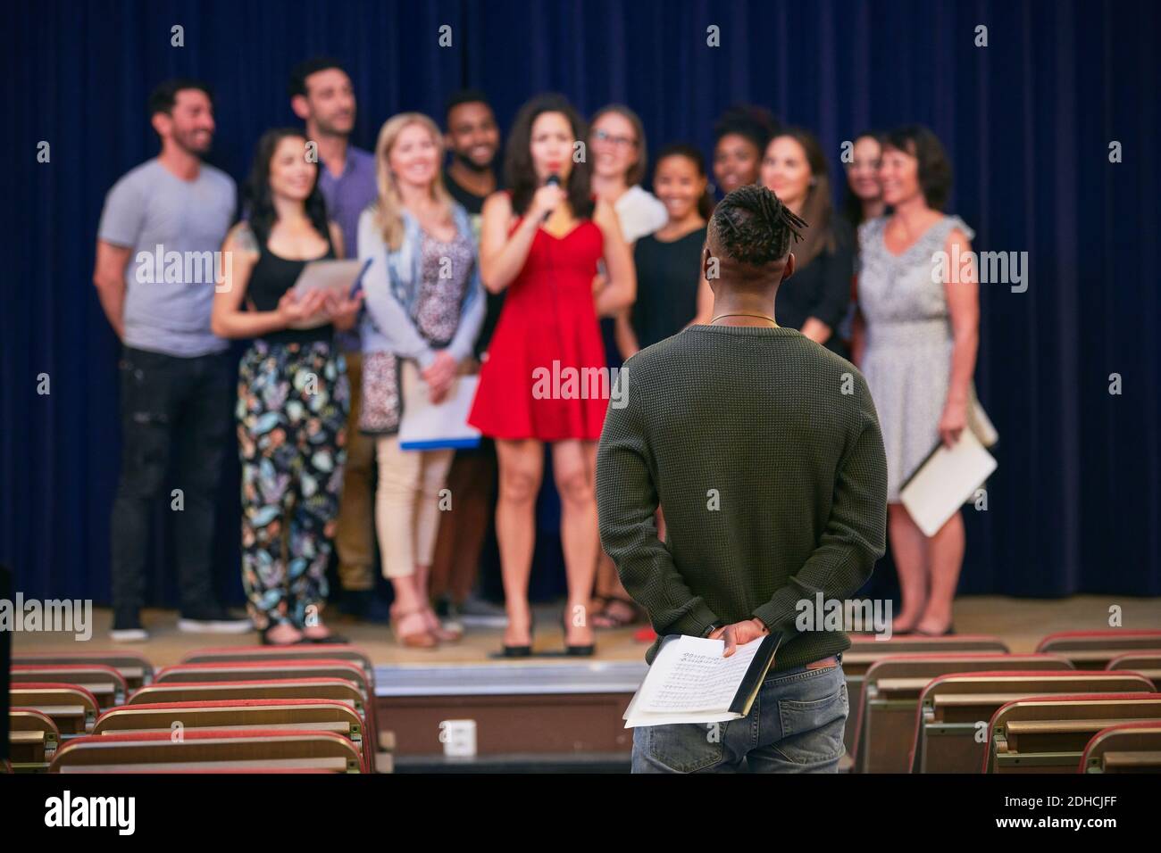 Musical conductor listening to choir on stage in language school Stock ...