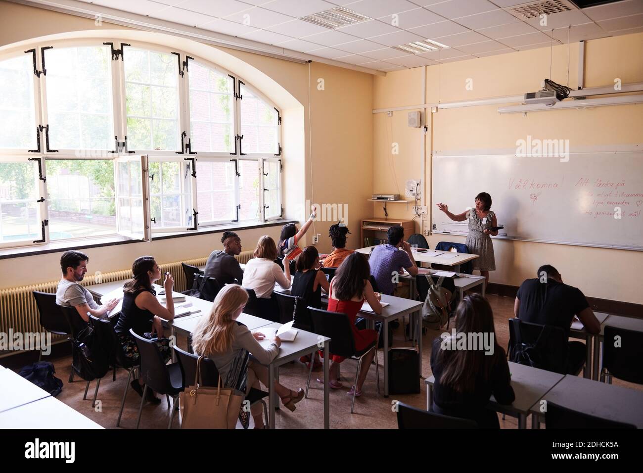 Female teacher asking questions to students in language school Stock ...