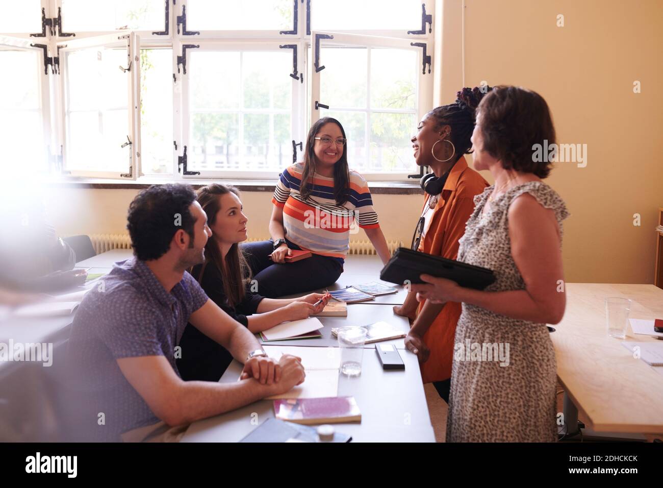 Happy students with teacher in language school Stock Photo - Alamy