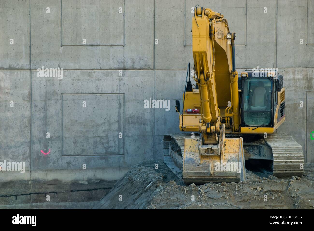 idling backhoe on a mound of rock Stock Photo - Alamy