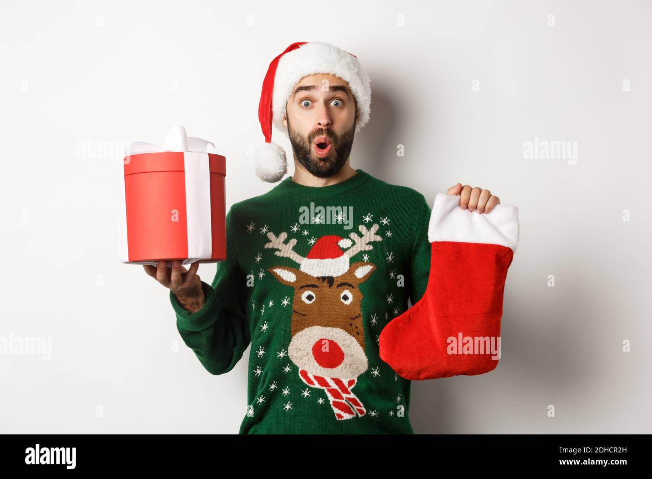 Xmas and winter holidays concept. Excited man holding christmas sock ...