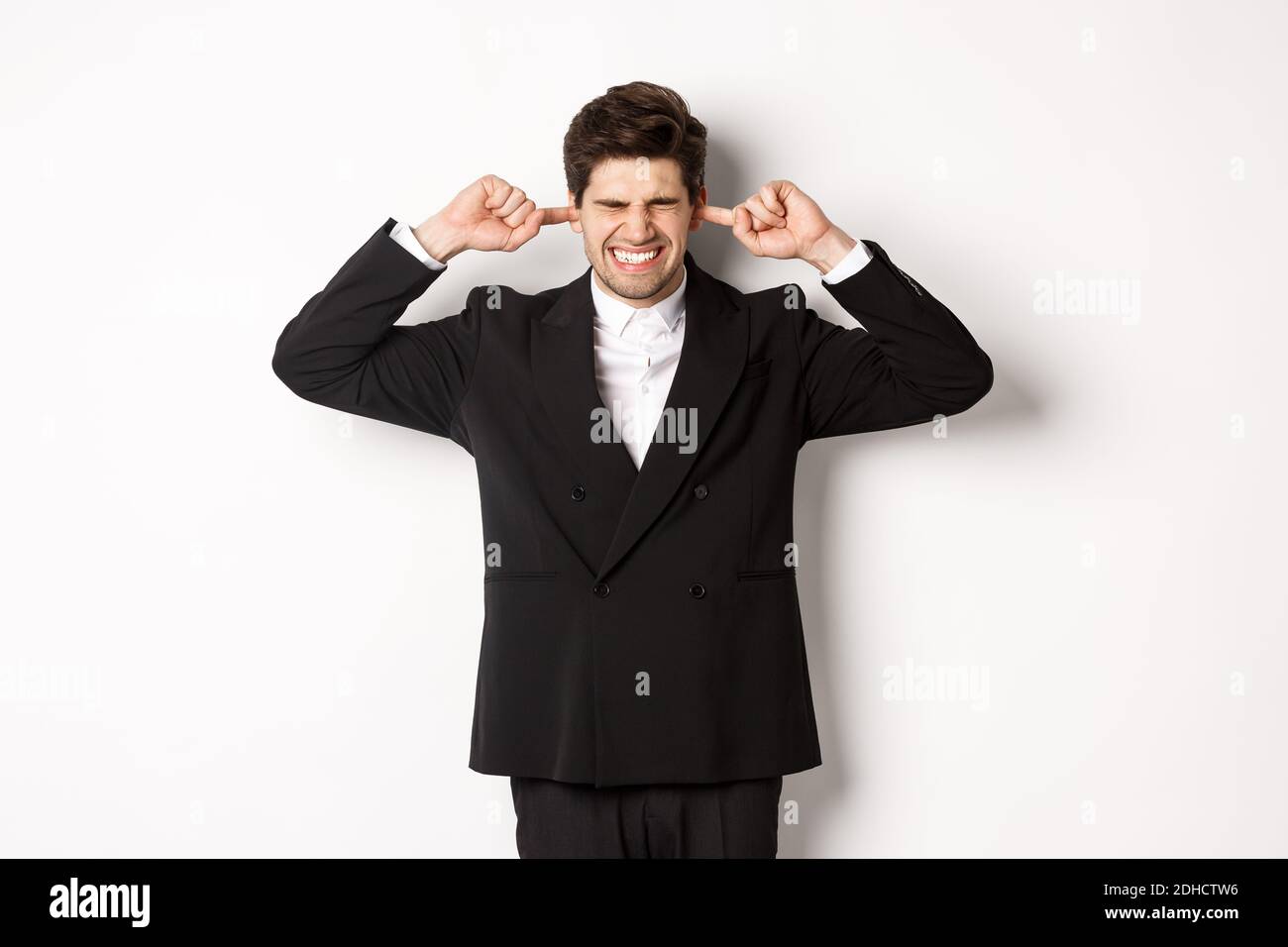 Portrait of annoyed and bothered businessman in black suit, shut ears ...