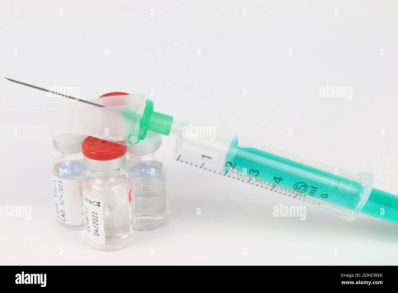 A shot of vaccine containers and a syringe isolated on a white ...