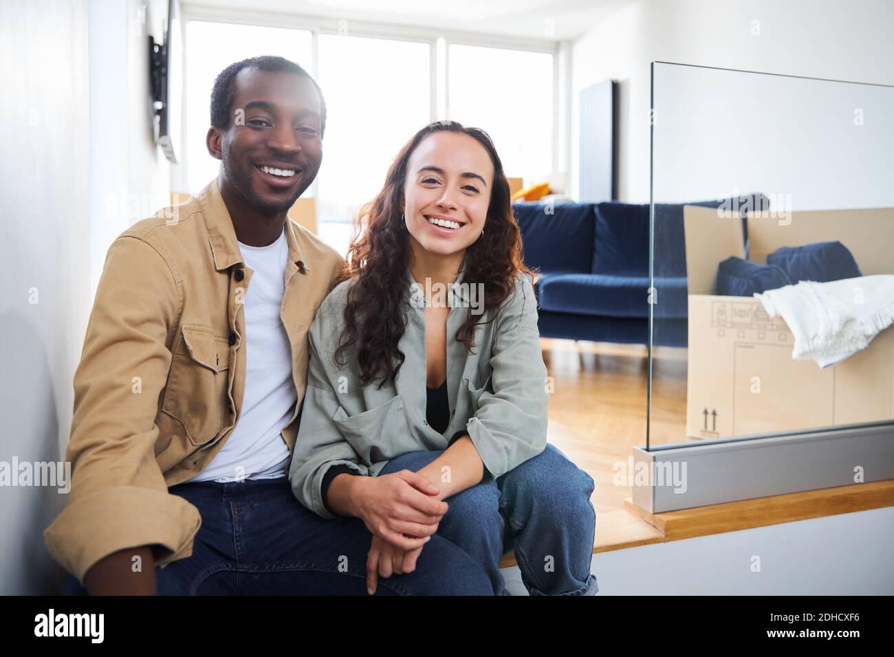 Portrait of young mixed ethnicity couple celebrating moving day in ...