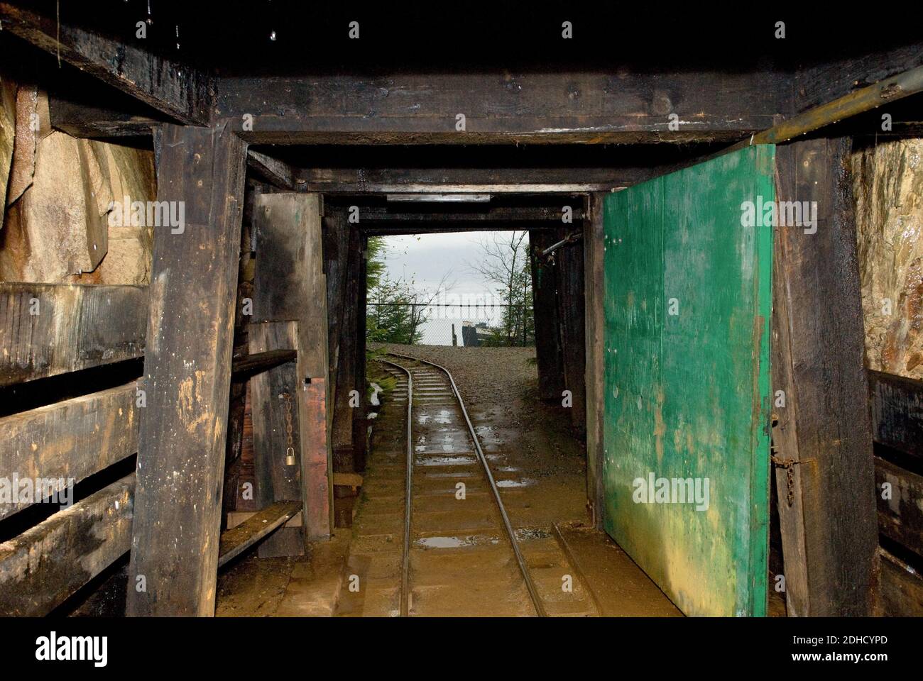 An entrance of a copper underground mine with rails covered in dirty ...