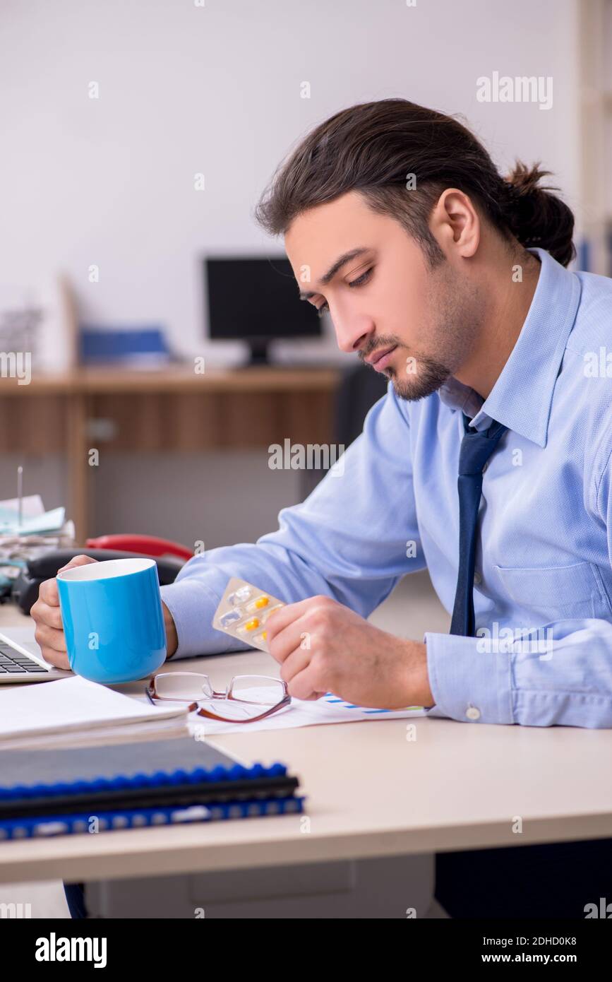 Sick male employee suffering at workplace Stock Photo - Alamy