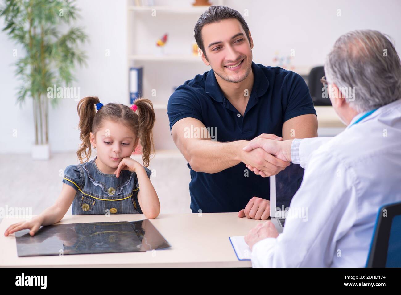 Young father and his daughter visiting old male doctor Stock Photo - Alamy