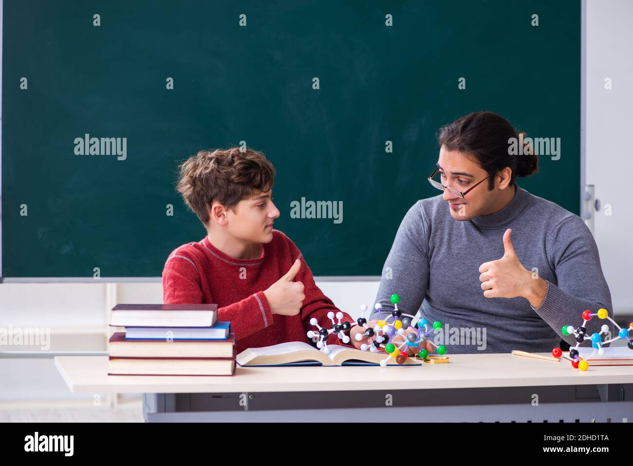Young male teacher and schoolboy in the classroom Stock Photo - Alamy