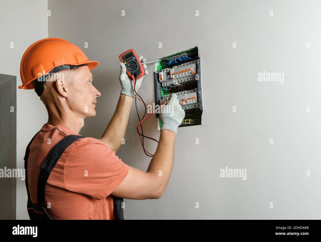 The electrician is checking with a multimeter the correctness of the ...