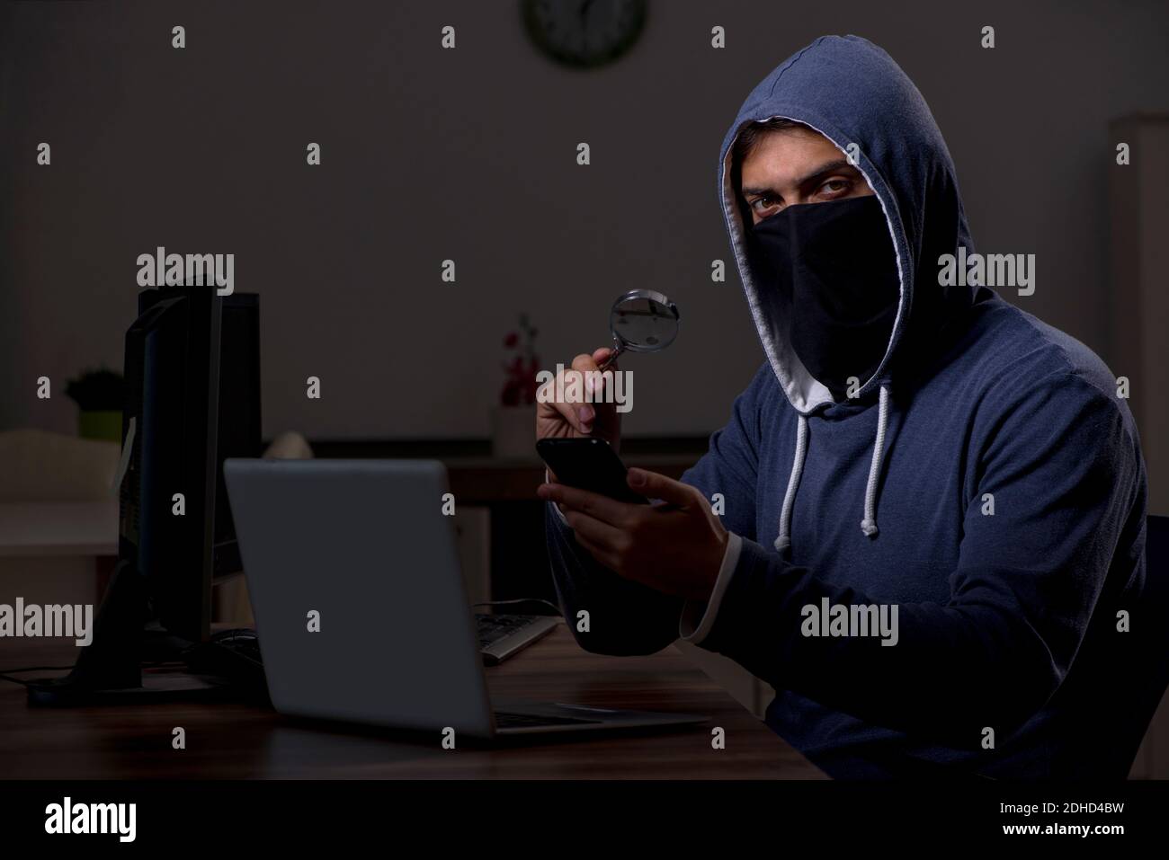 Male hacker hacking security firewall late in office Stock Photo - Alamy