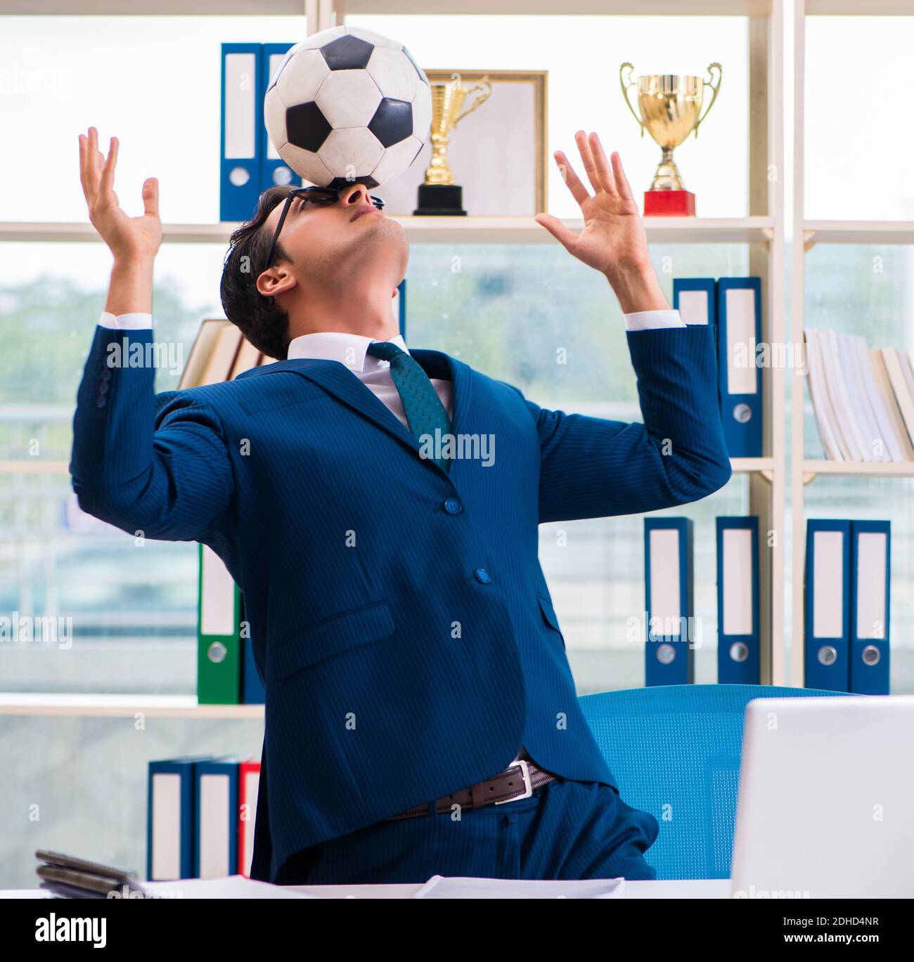 Businessman playing football in the office Stock Photo - Alamy