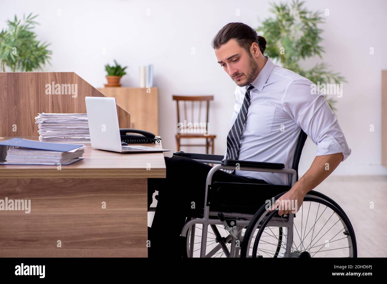 Young disabled employee suffering at workplace Stock Photo - Alamy