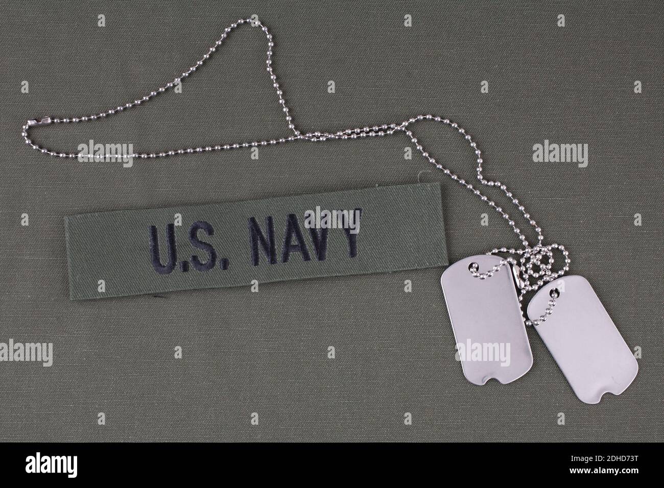 U.S. Navy Branch Tape with dog tags on olive drab uniform background ...